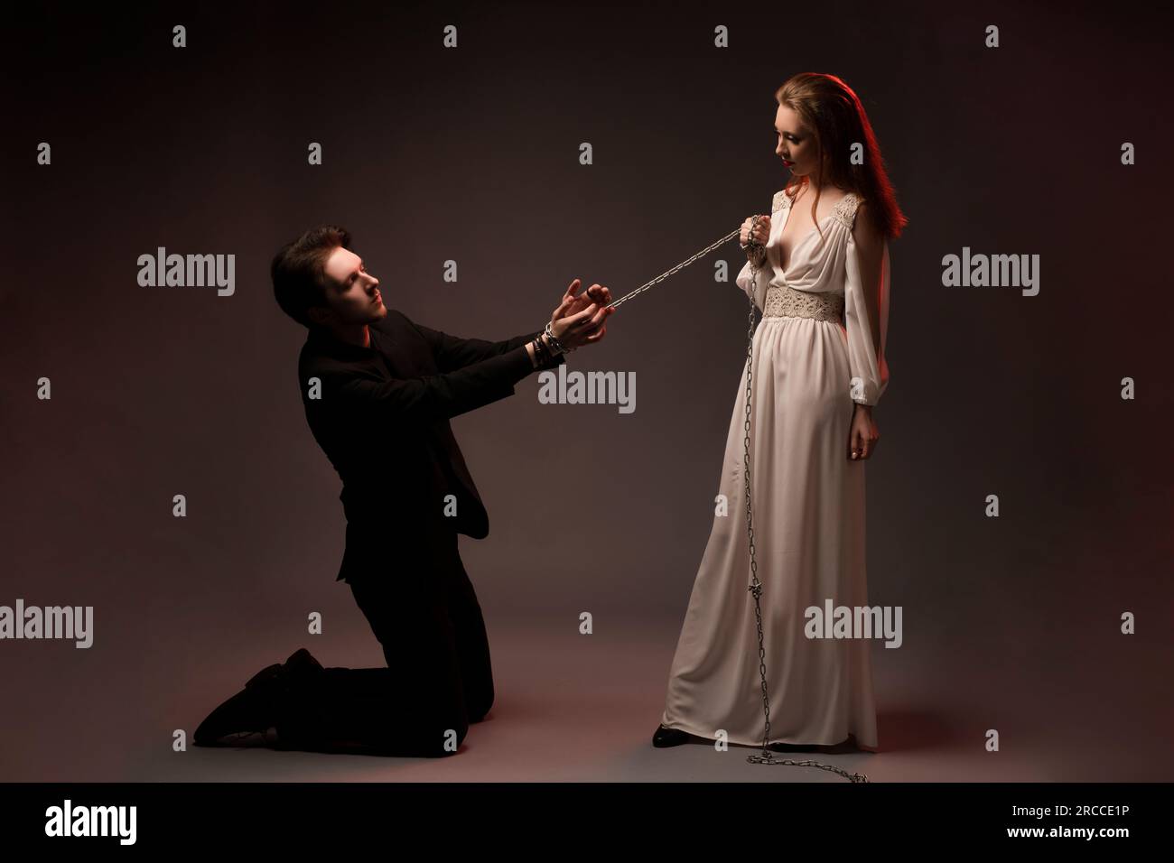 Man with tied hands kneeling near woman Stock Photo - Alamy