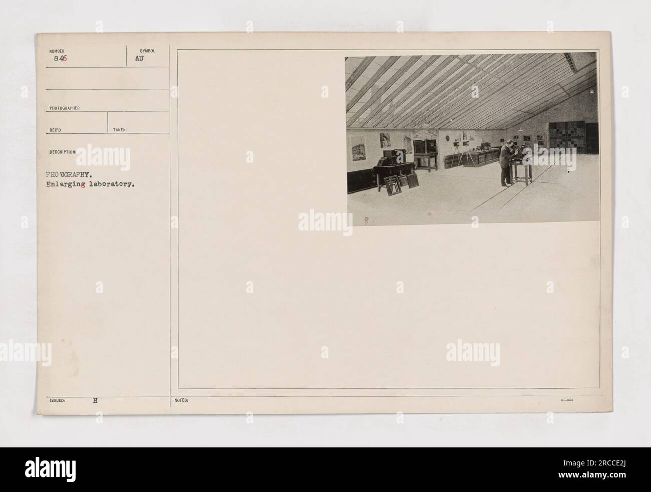 A soldier in a military photography lab is seen operating an enlarging ...