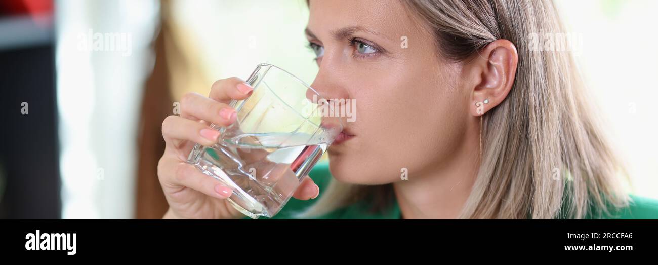 Close-up of unhappy woman with serious face drinking of non-carbonated water Stock Photo - Alamy