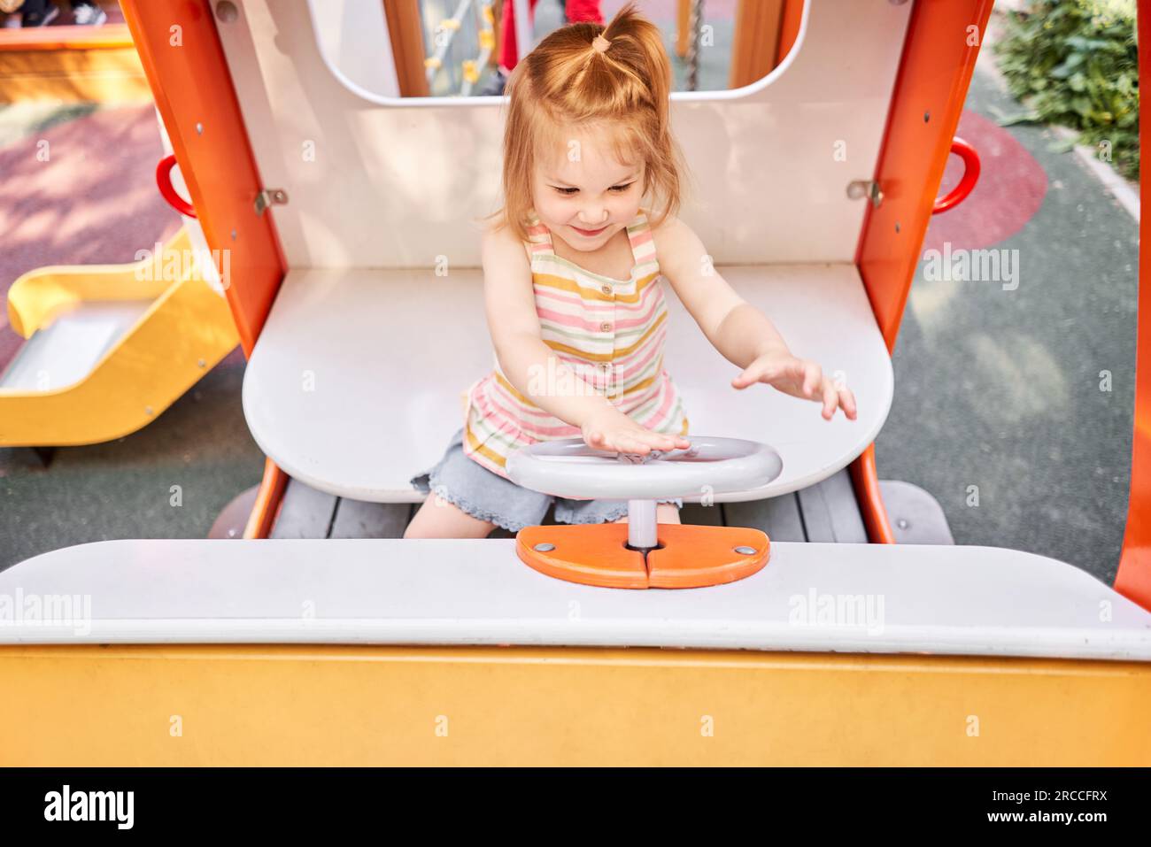 Little girl playing, she is a car driver holding steering wheel on ...