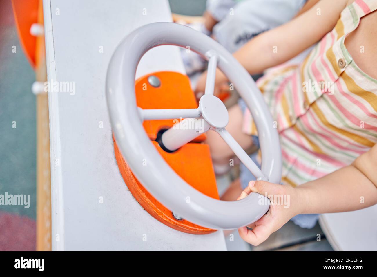 Little girl playing, she is a car driver holding steering wheel on ...