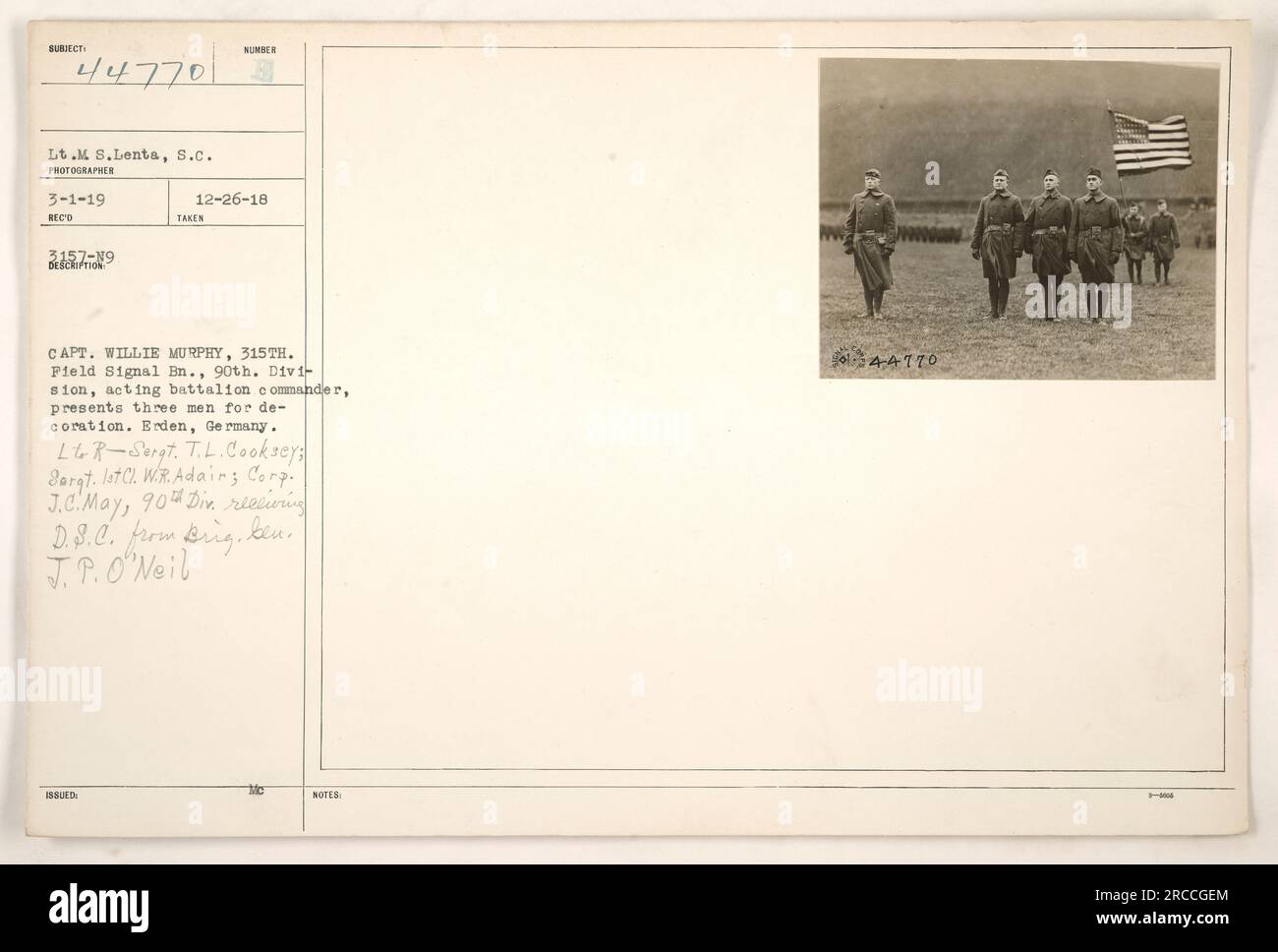 Lieutenant M. S. Lenta is photographed presenting three men for ...