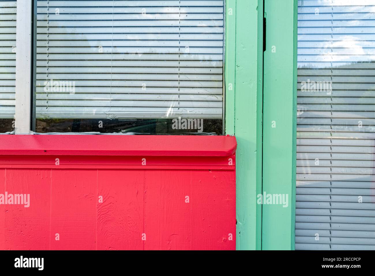The exterior wall, window, and door of a building, painted red and ...