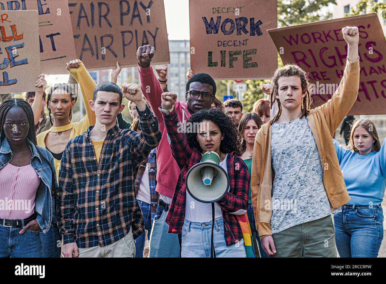 A group of multiethnic youth protesting for fair pay and work access ...