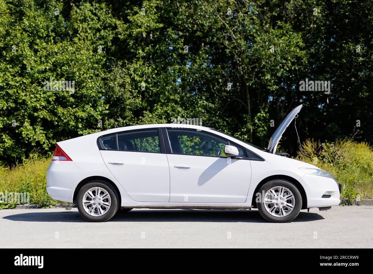Side view of white car with open hood Stock Photo - Alamy