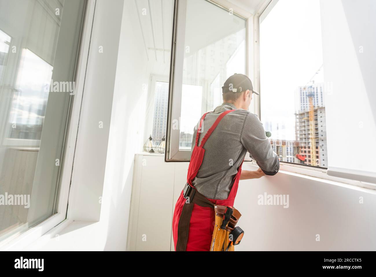 The foreman installs a window frame in the room Stock Photo - Alamy