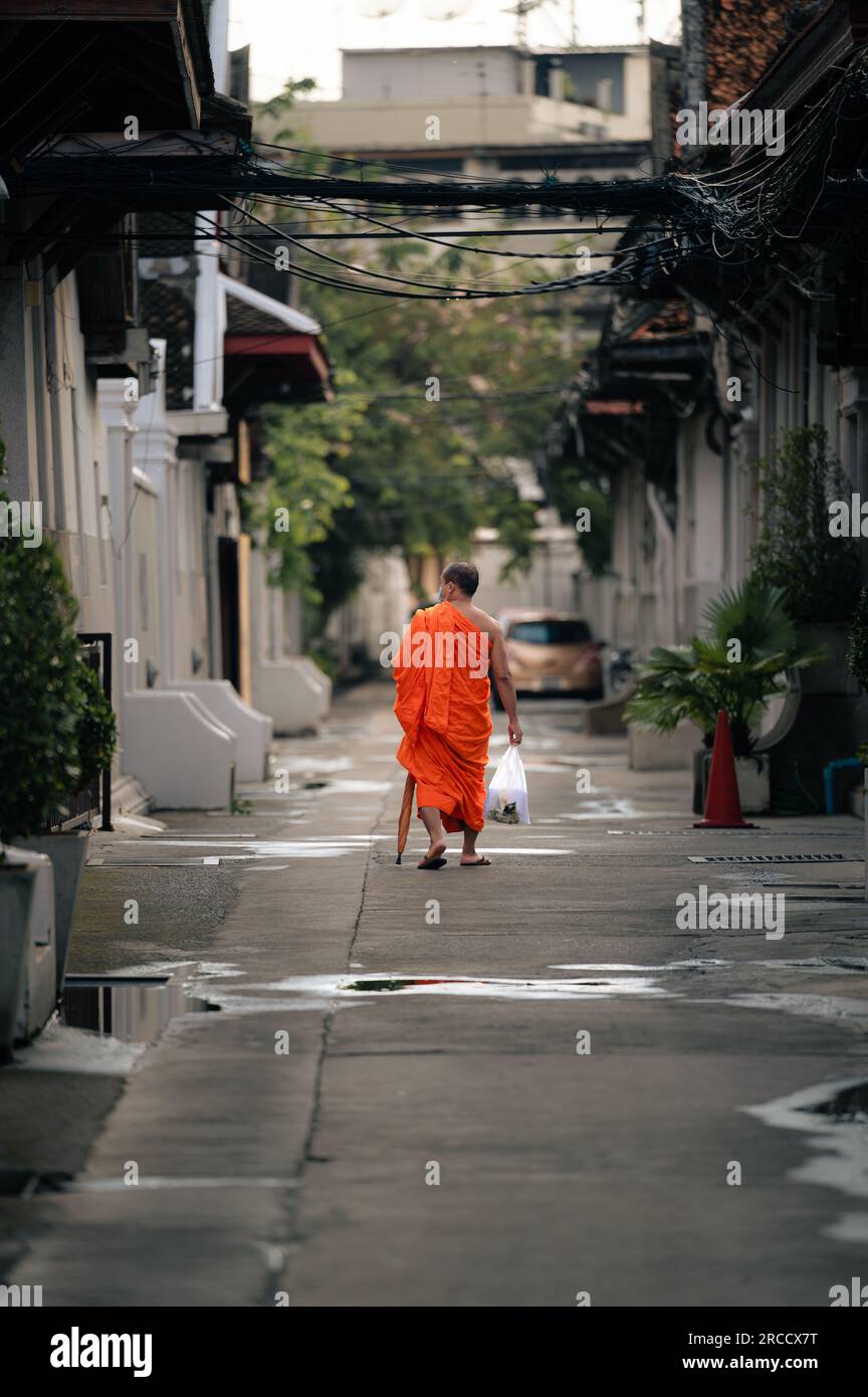 A Buddhist monk walks along the street carrying a humble bag in his ...