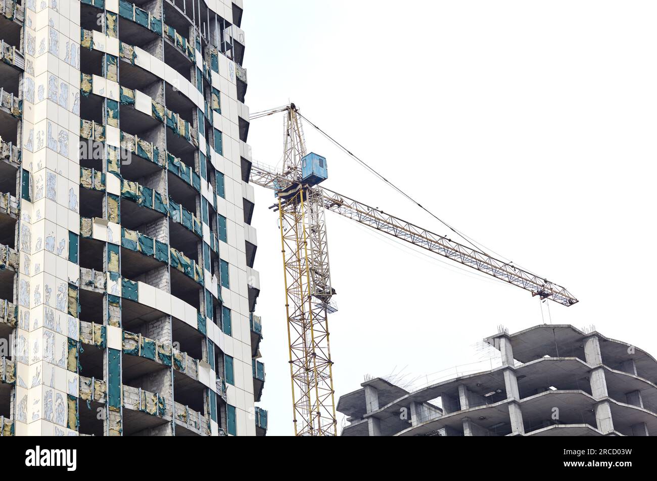 Tower crane building a house. Concrete building under construction ...