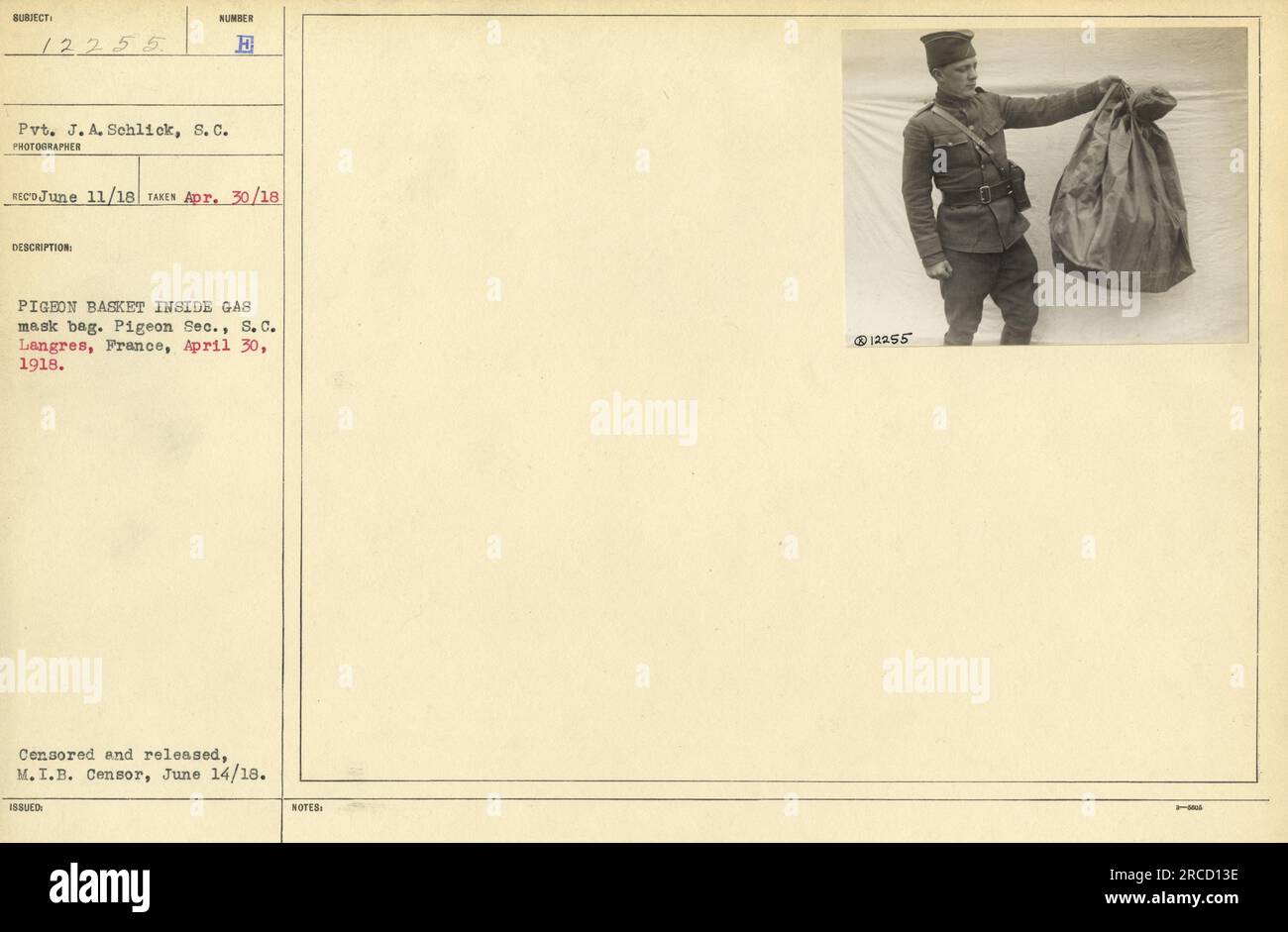 Private J. A. Schlick carrying a pigeon basket inside a gas mask bag ...