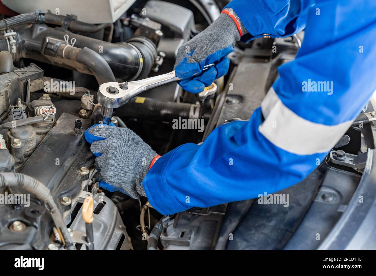 Close up hands of a male car mechanic using retchet wrench while ...
