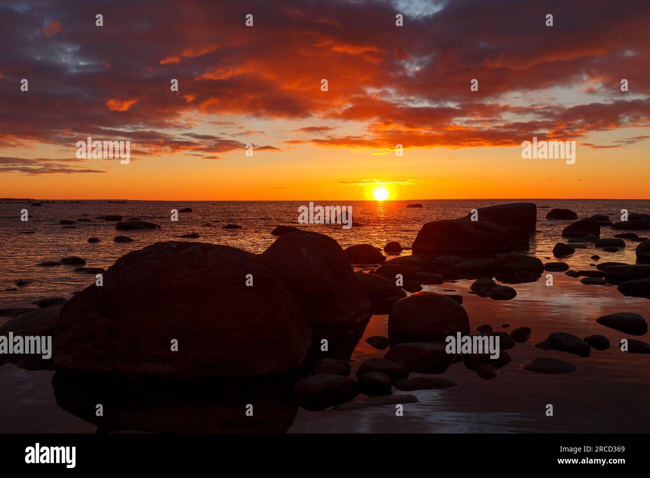 Beautiful view of shallow see rocky shore at the red colored sunset ...