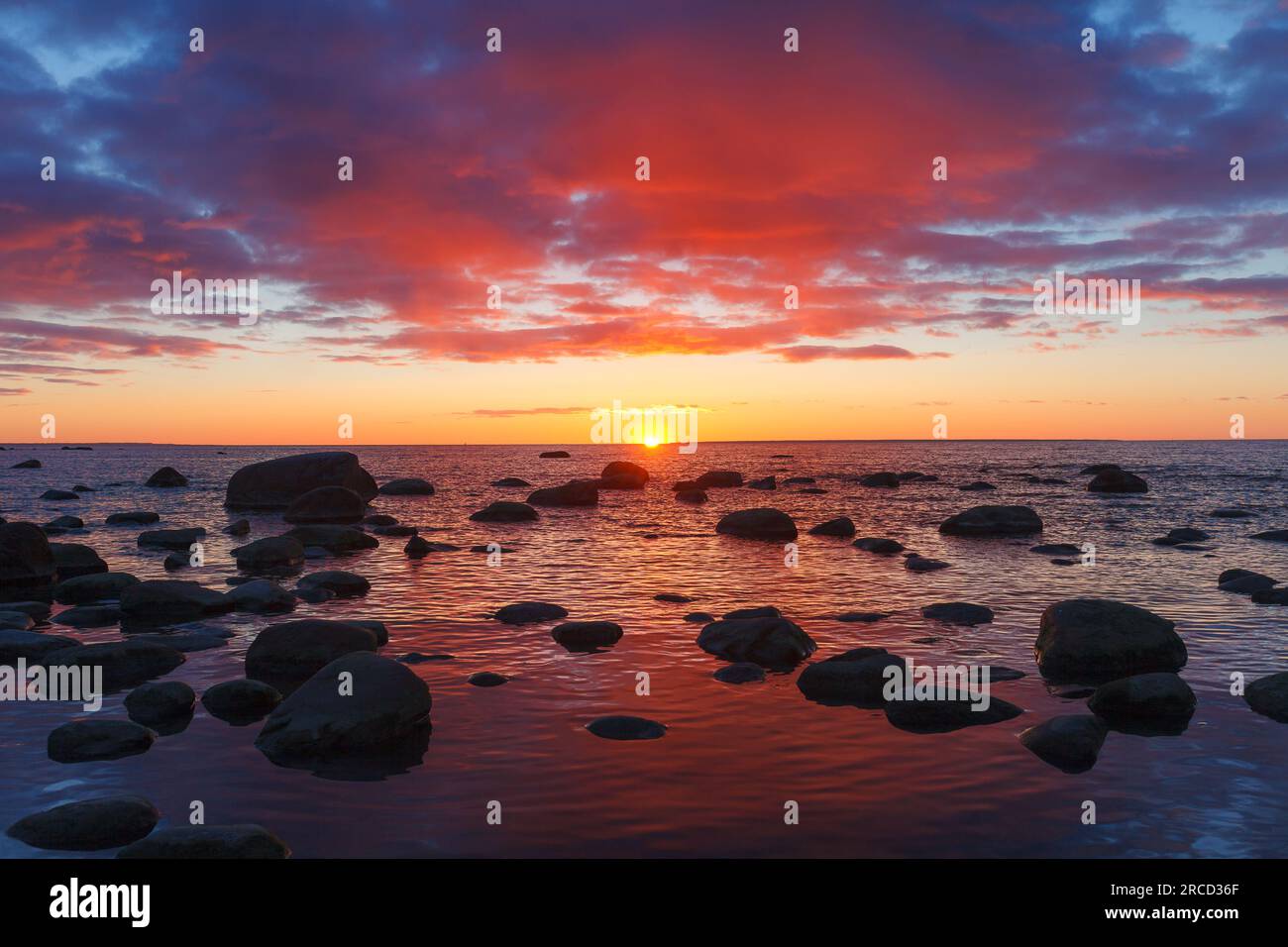 Beautiful view of shallow see rocky shore at the red colored sunset ...