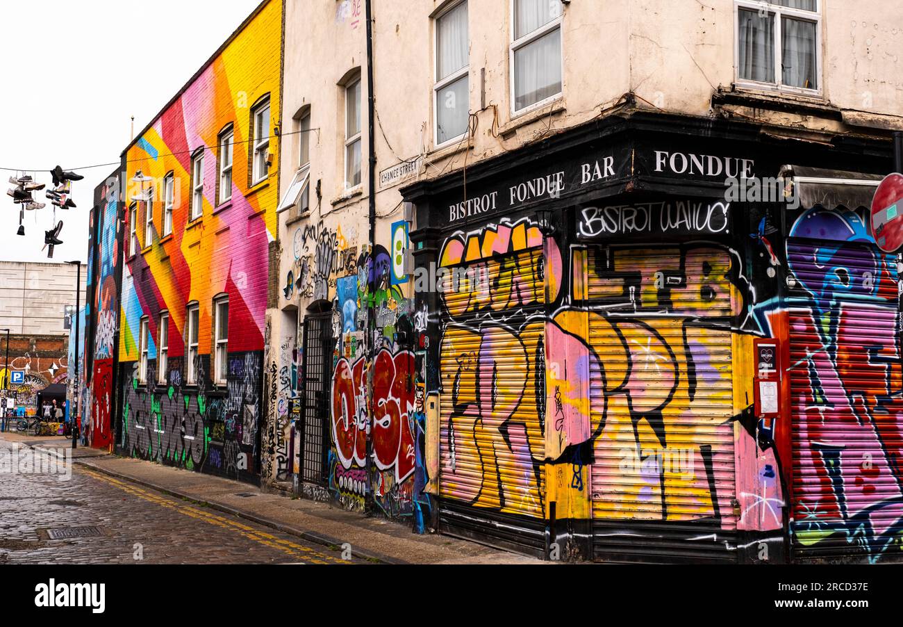 Graffiti and hanging shoes from telephone wires on buildings on a wet ...