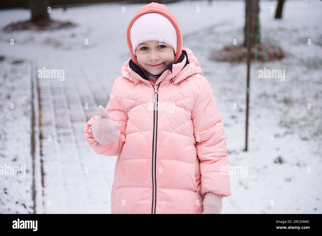 Caucasian lovely little kid girl with rosy cheeks, wearing pink warm ...