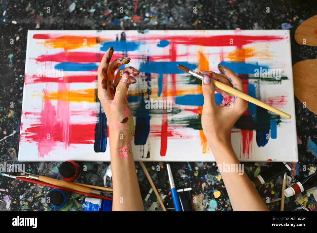 Overhead view of man painting on canvas with watercolors at art class ...