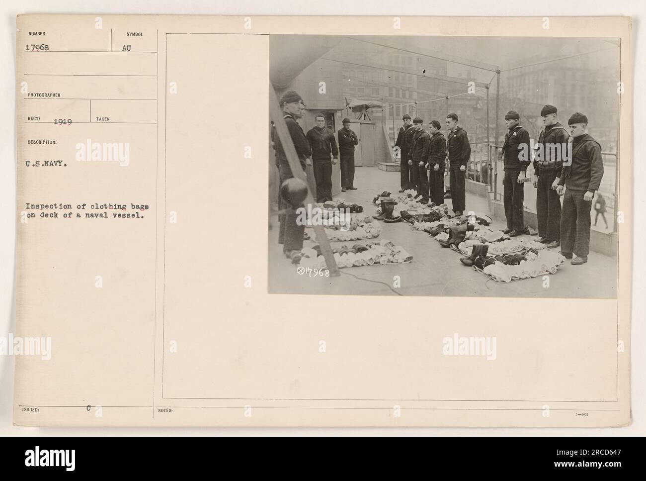 Officer inspecting clothing bags on the deck of a U.S. Navy vessel ...