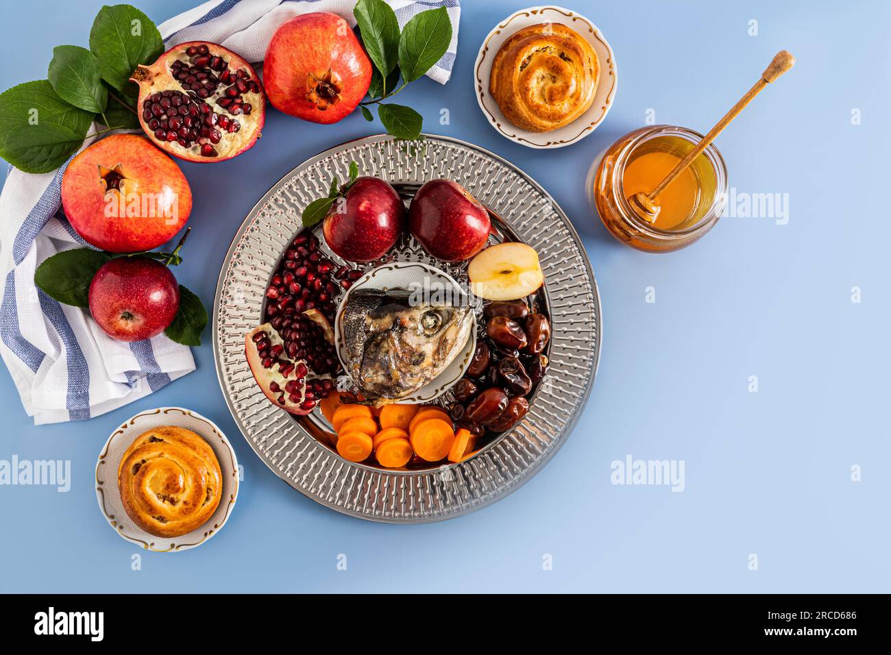 A silver dish with traditional food Rosh Hashanah. pomegranates, apples ...