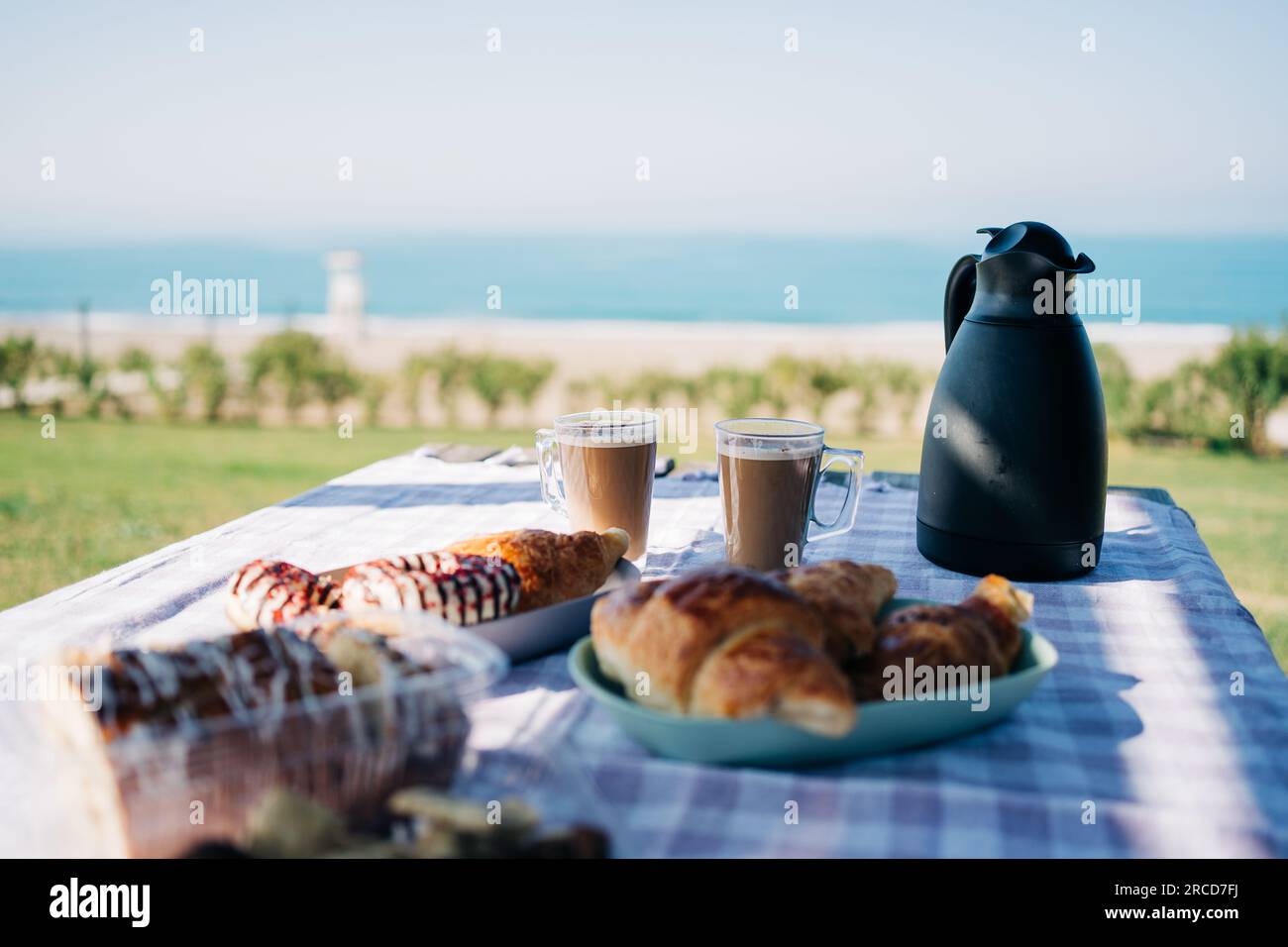 A picnic at the seaside beach. Breakfast with coffee, croissants and ...