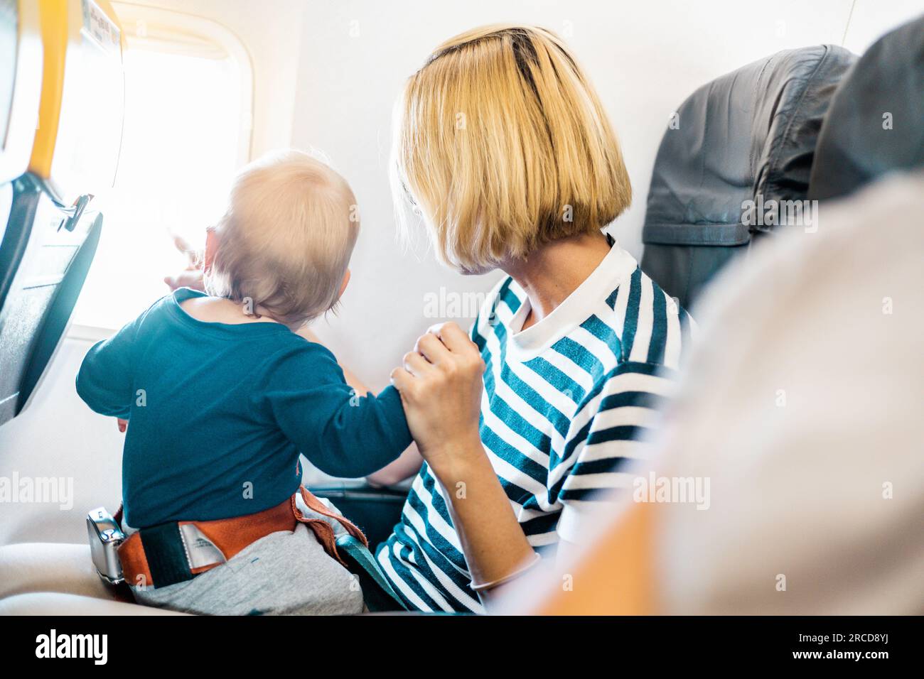 Mom and child flying by plane. Mother holding and playing with her ...