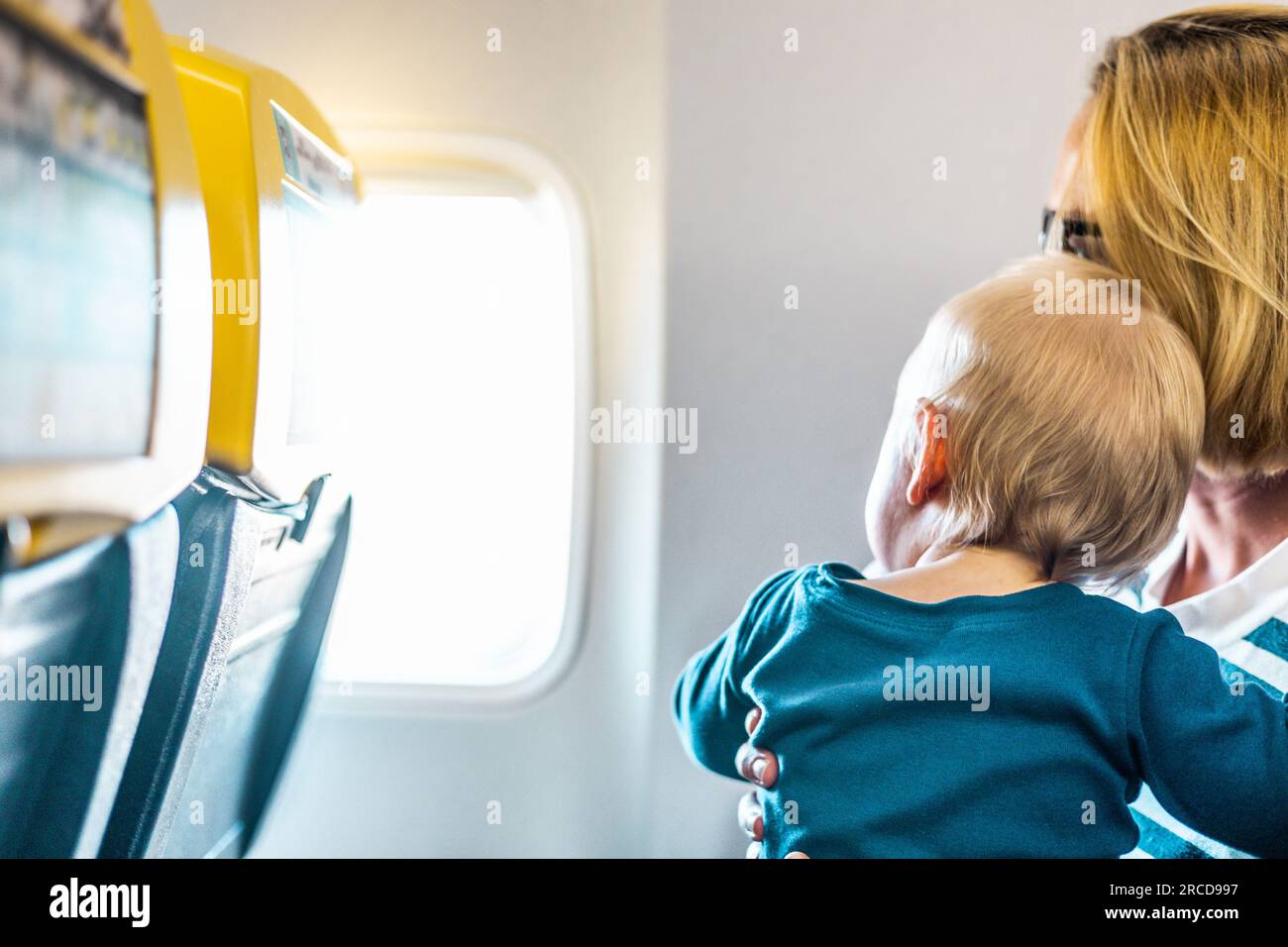 Mom and child flying by plane. Mother holding and playing with her ...