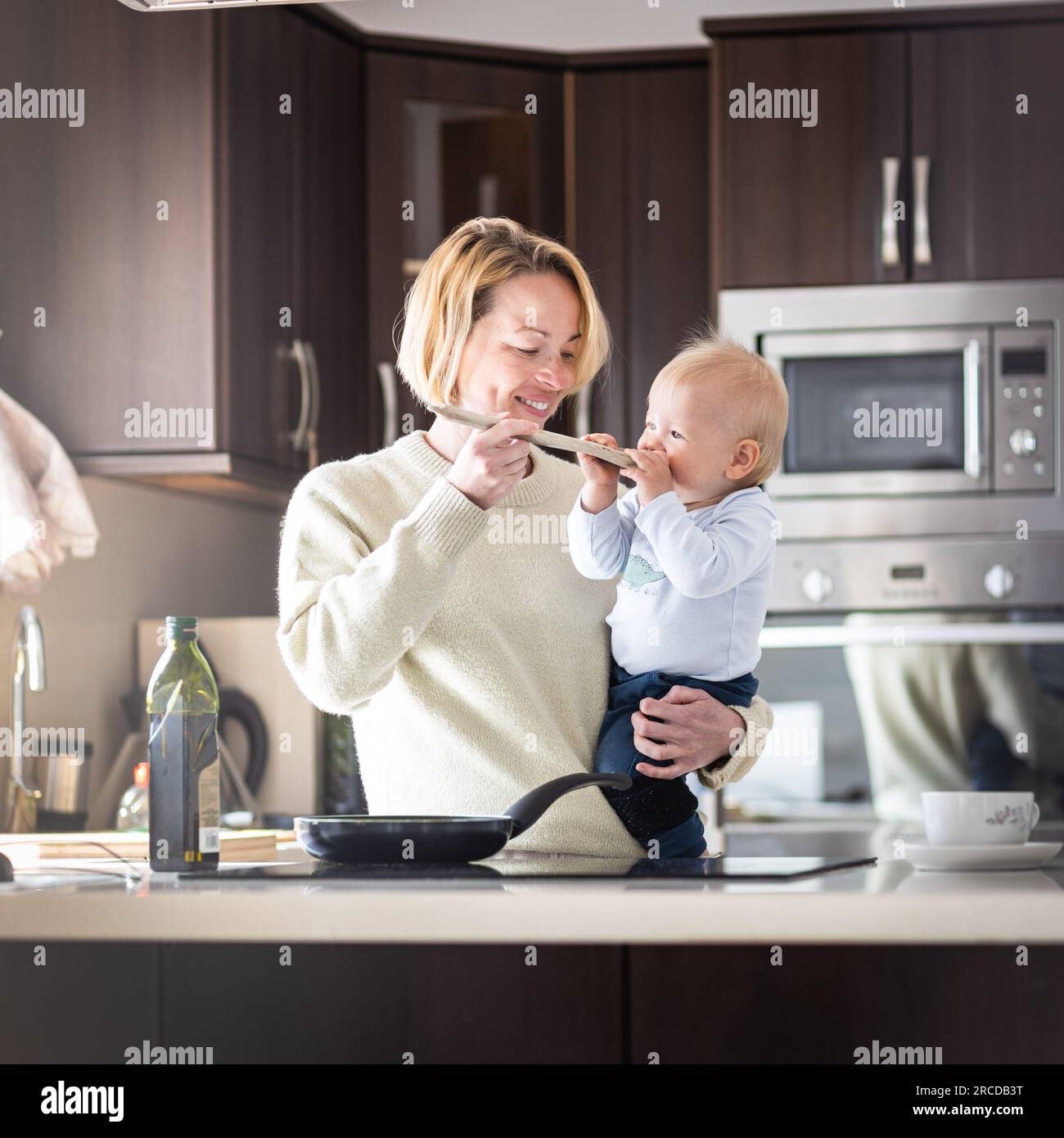 Happy mother and little infant baby boy cooking and tasting healthy ...