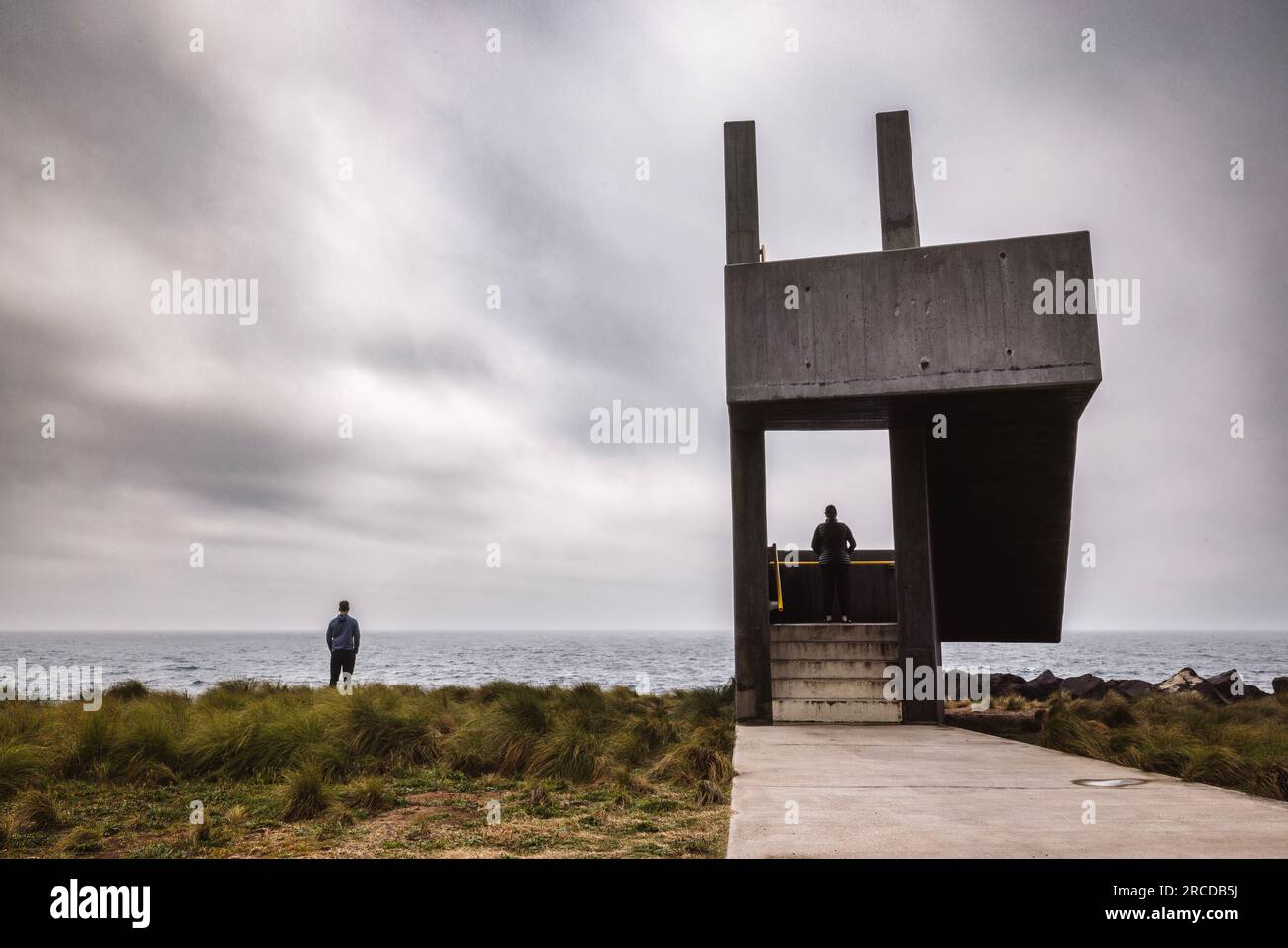 Two people at concrete watchtower by the ocean, Lagoa, Azores Stock ...
