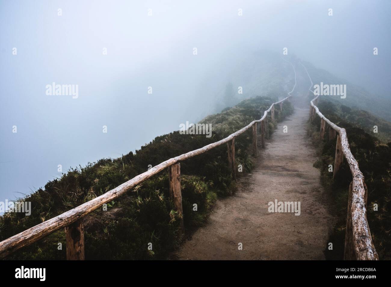 ridge top hiking path winds into fog and mist, Azores, Portugal Stock ...