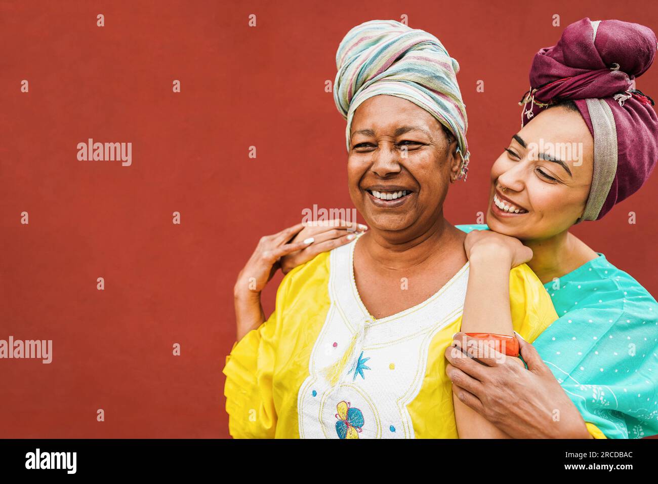 Happy african mother and daughter wearing traditional clothes - Motherhood, ethnic cultures and ...