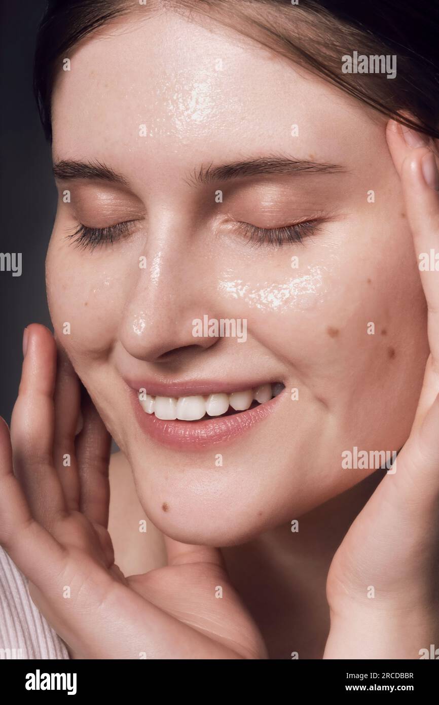 Face skin care. Woman applying a mask on clean hydrated skin portrait ...