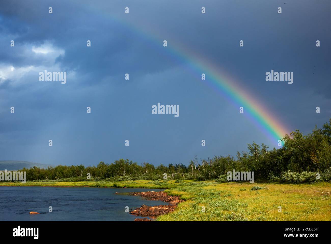 Rainbow by the side of the Lainio river in the Swedish Lapland with ...