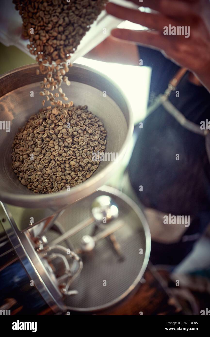 close up detail of whole grain coffee spilling from plastic dish into a ...