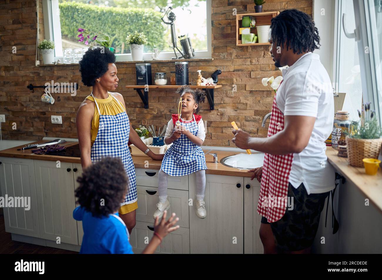 Afro-American family comes together around the kitchen counter. The ...