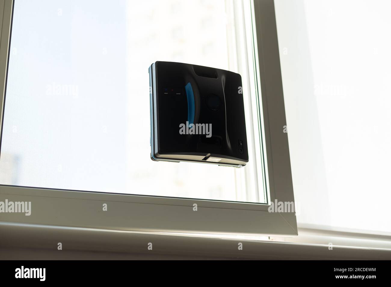 The white robotic window cleaner uses a brush and vacuum for a thorough ...