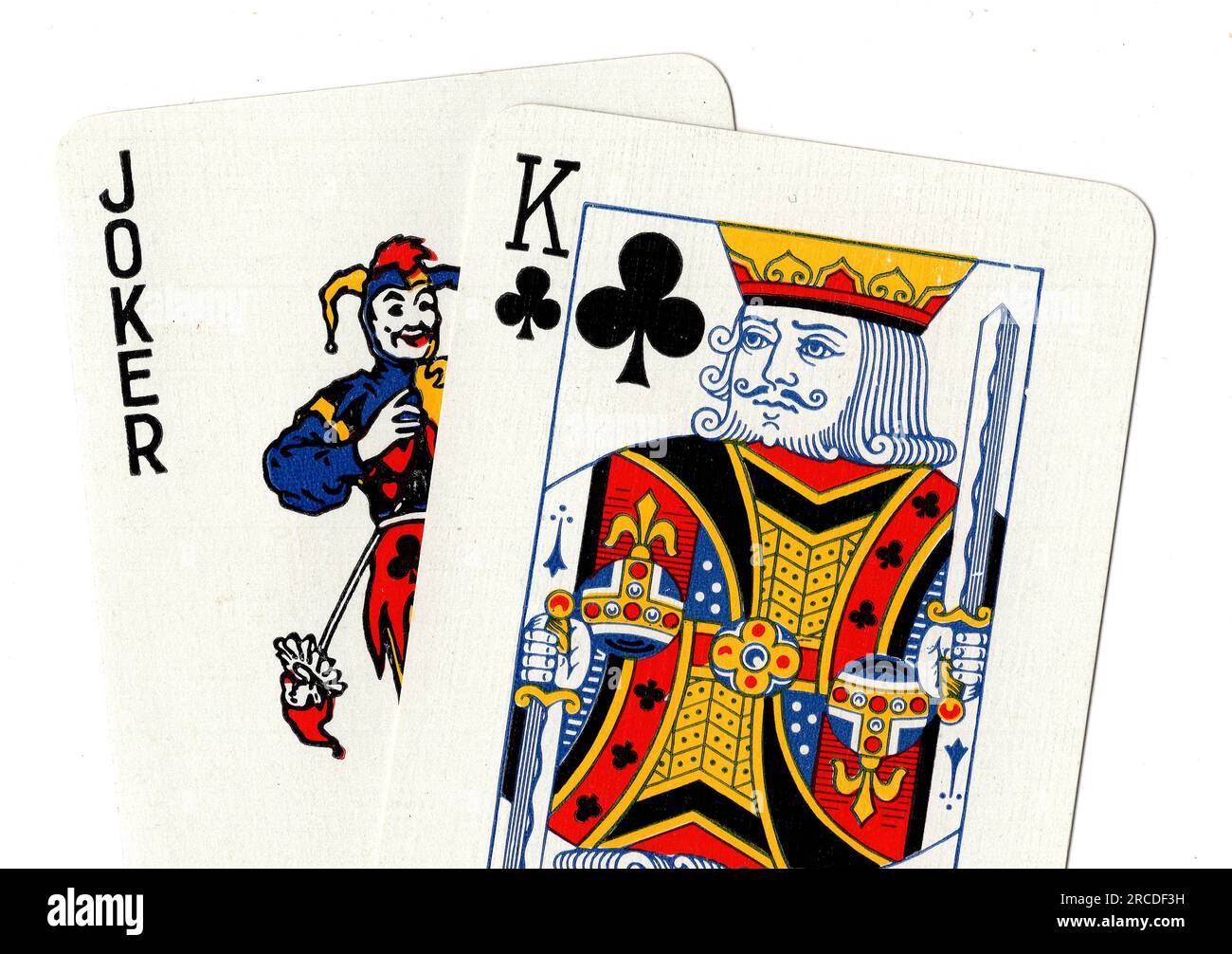 Vintage playing cards showing a joker and a king of clubs on a white ...