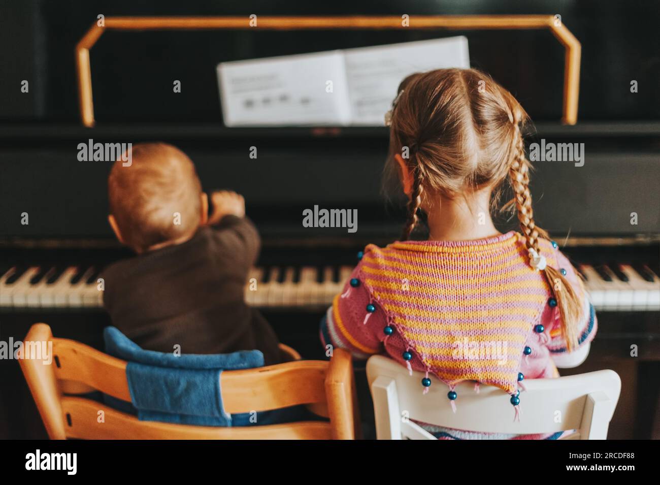 Two little kids playing on piano, toddler girl and baby boy practicing ...