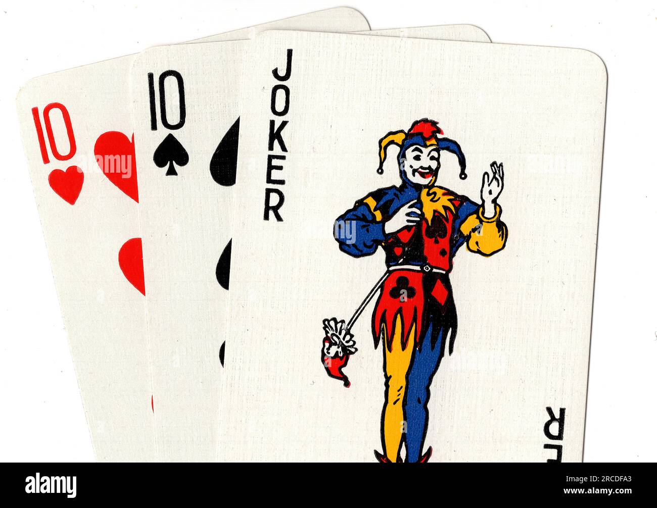 Vintage playing cards showing a joker and a pair of tens on a white ...