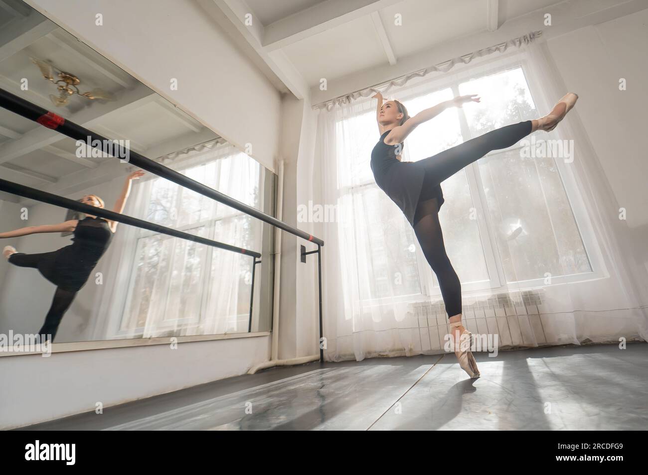 A beautiful Asian woman is dancing at the barre. Ballet dancer Stock ...