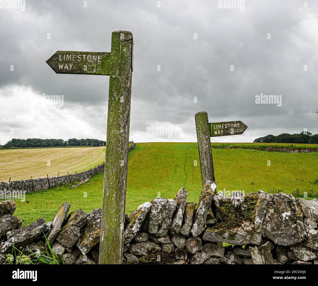 Limestone Way waymarkers either side of a drystone wall near Monyash in ...