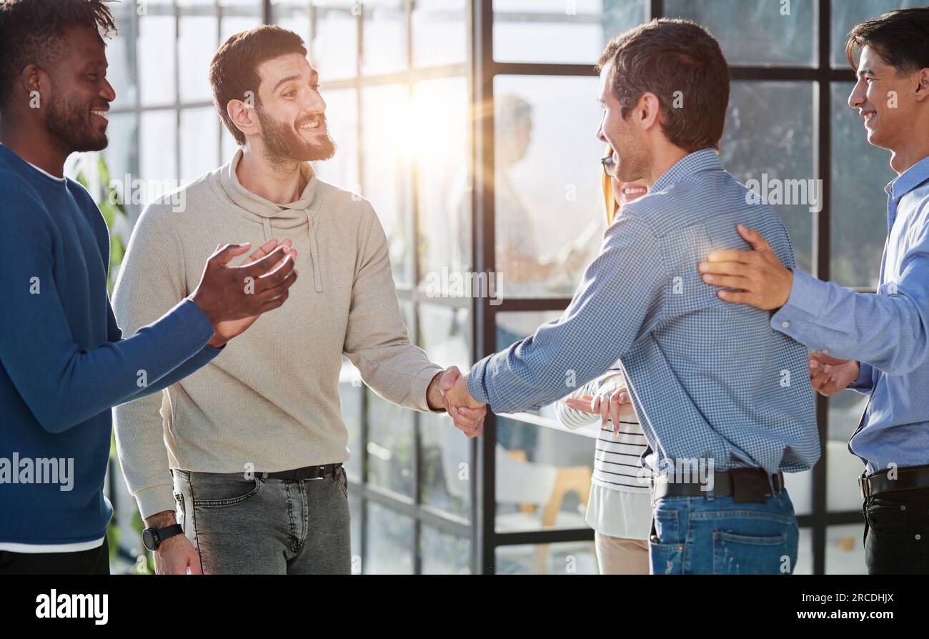 Happy colleagues welcome businessman to their successful team Stock ...