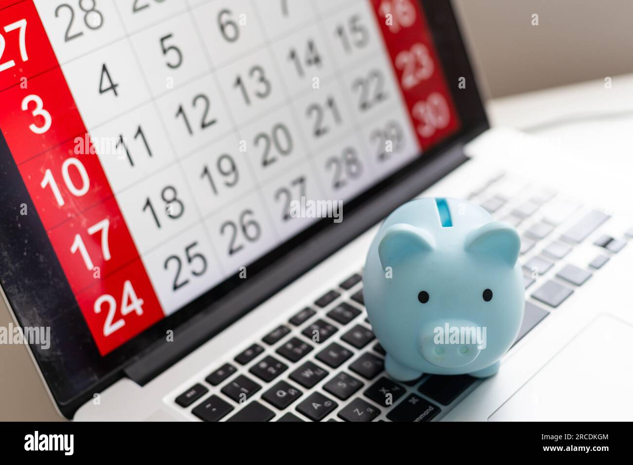 Saving money concept. Piggy bank on calendar with calculator, notepad ...
