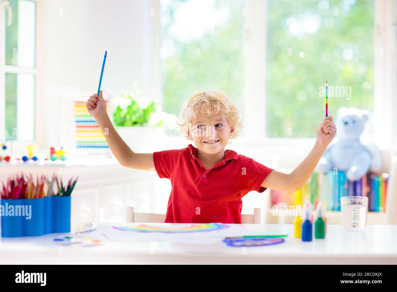 Kids paint. Child painting in white sunny study room. Little boy ...