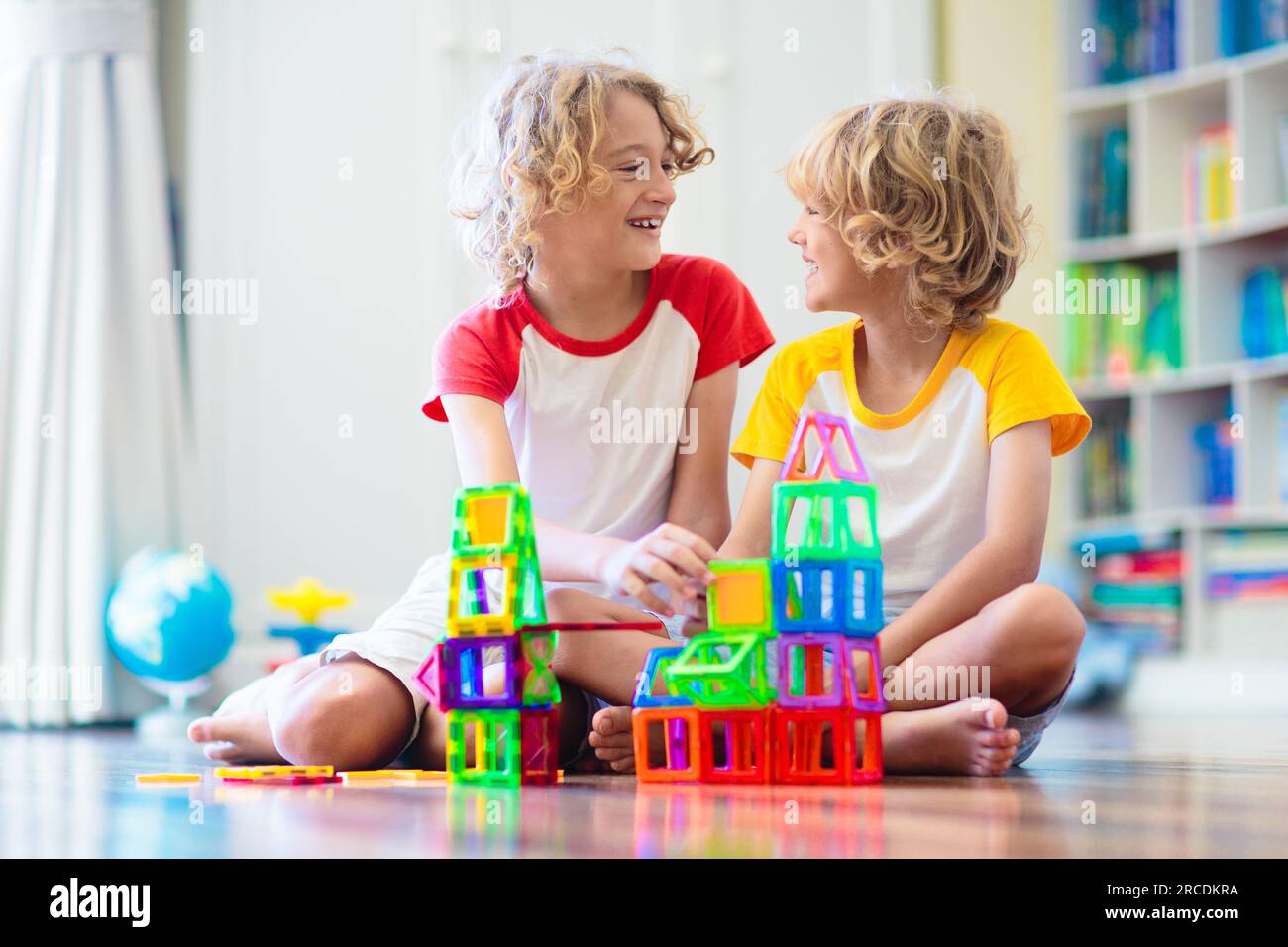 Child playing with magnetic building blocks. Little boy building tower ...