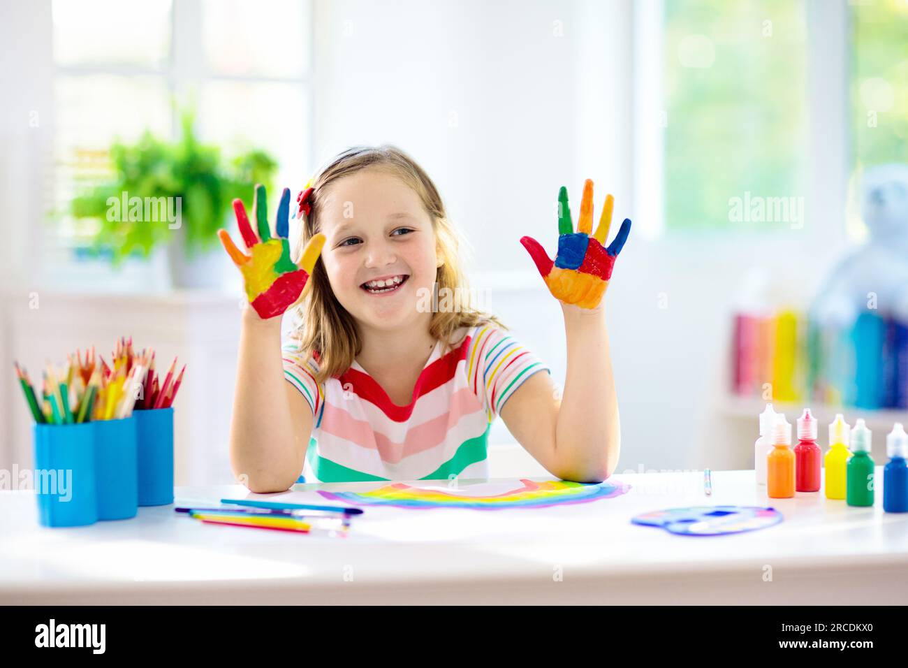 Kids paint. Child painting in white sunny study room. Little girl ...