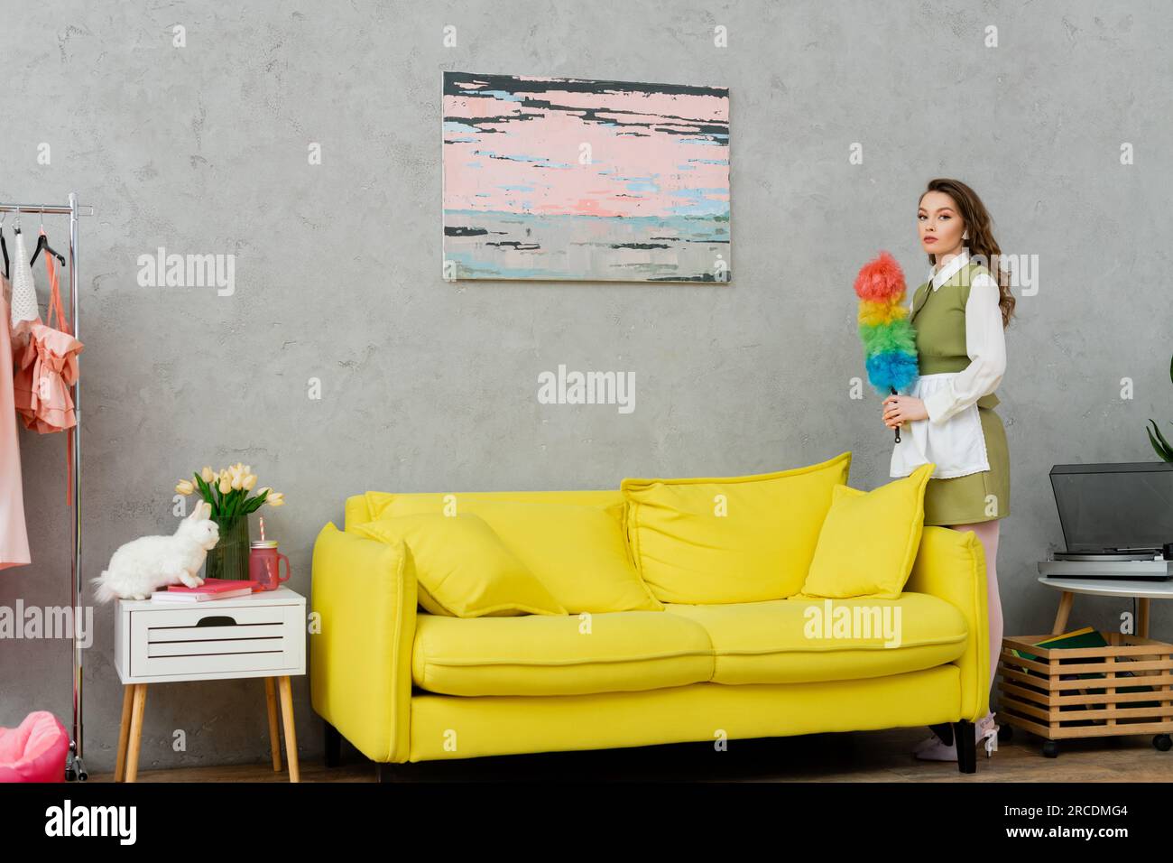 housekeeping concept, young woman with brunette wavy hair holding dust ...