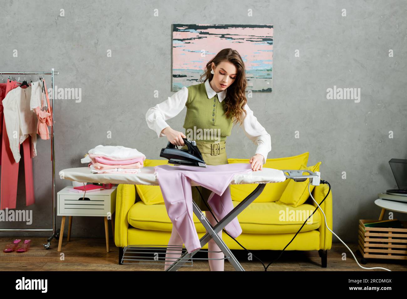 housework concept, beautiful young woman with wavy hair ironing ...