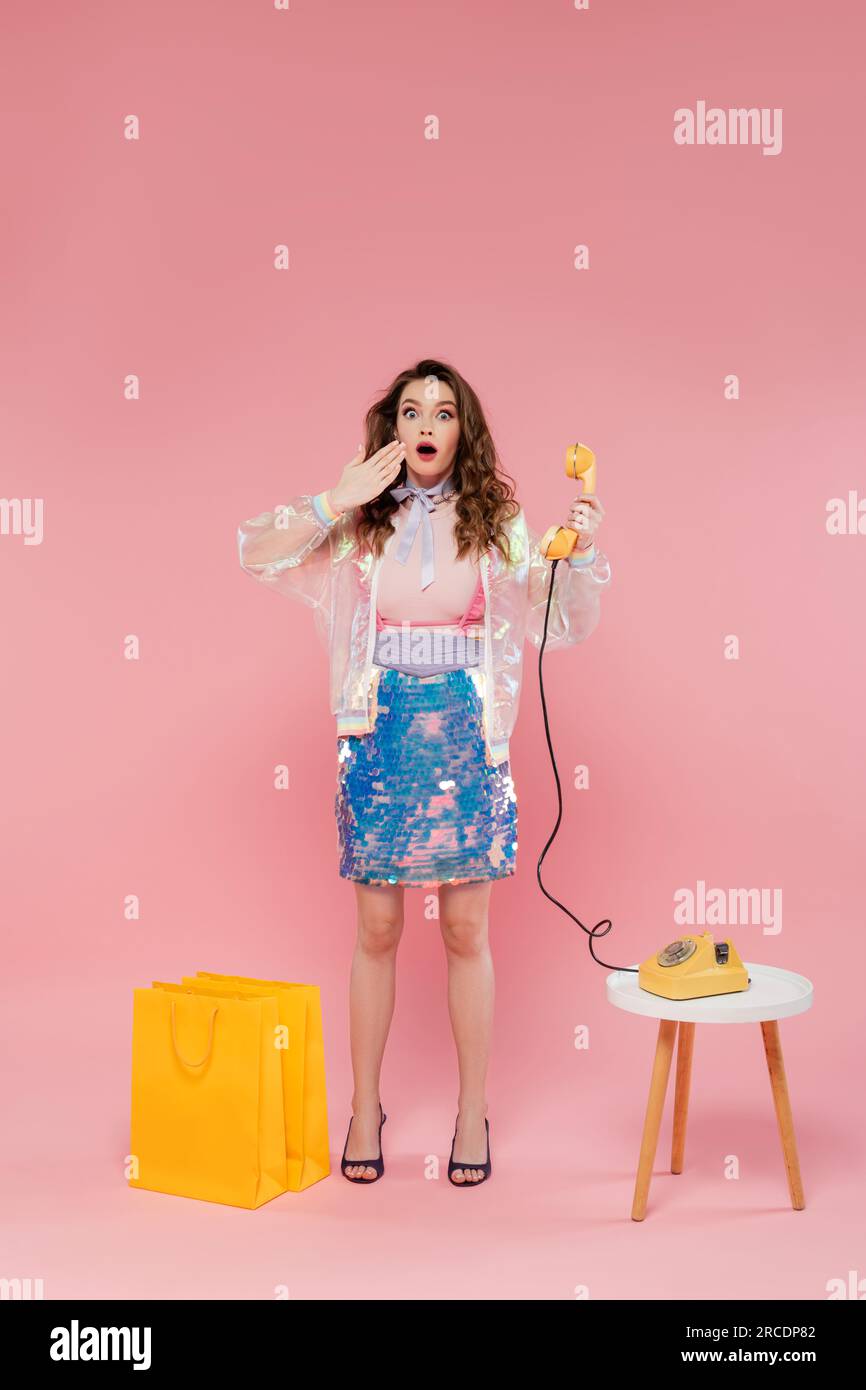 shocked woman posing near shopping bags, standing like a doll and ...