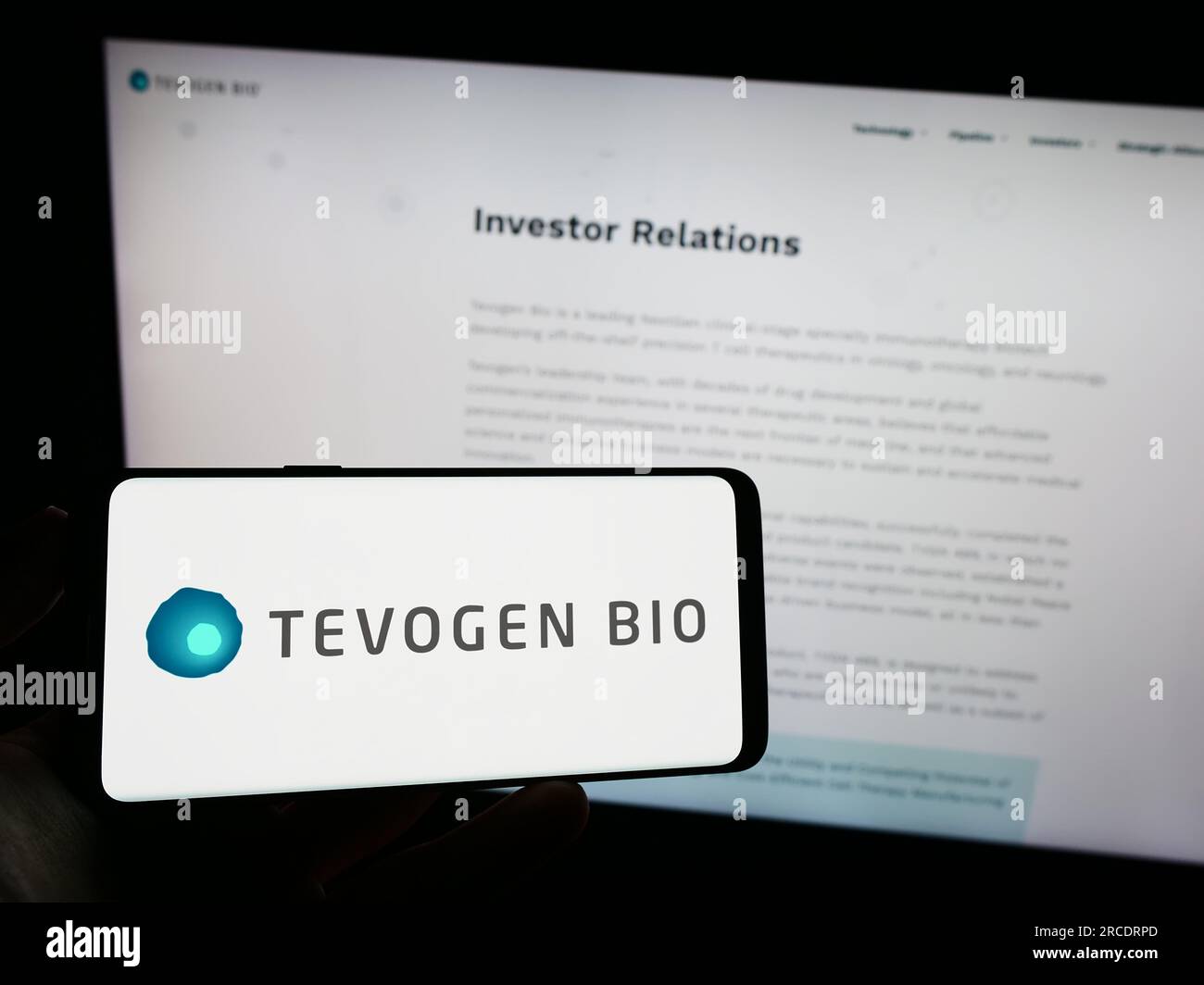 Person holding mobile phone with logo of American biotechnology company Tevogen Bio Inc. on ...