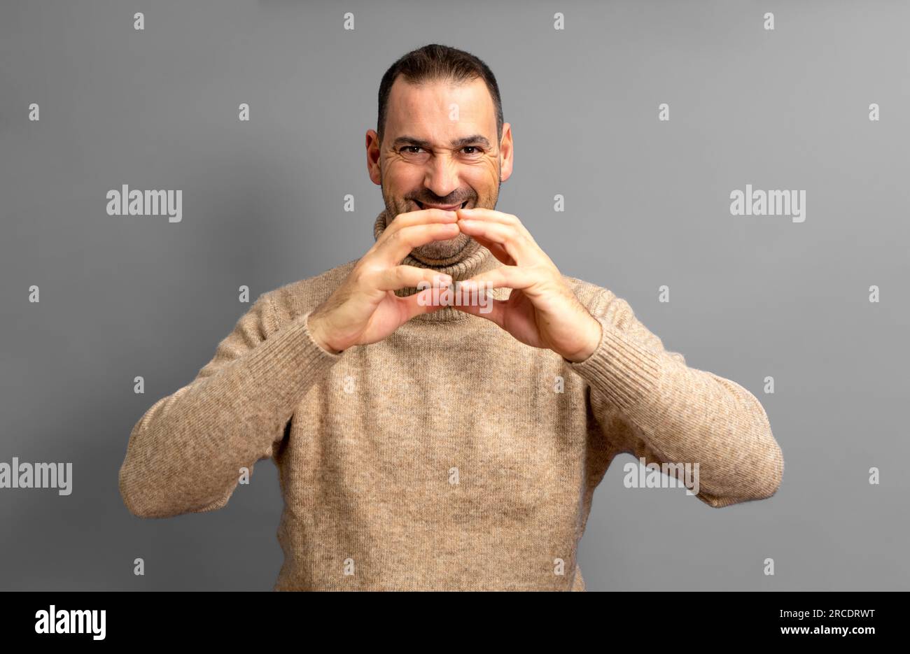 Hispanic man with a beard with the tips of his fingers together in an ...