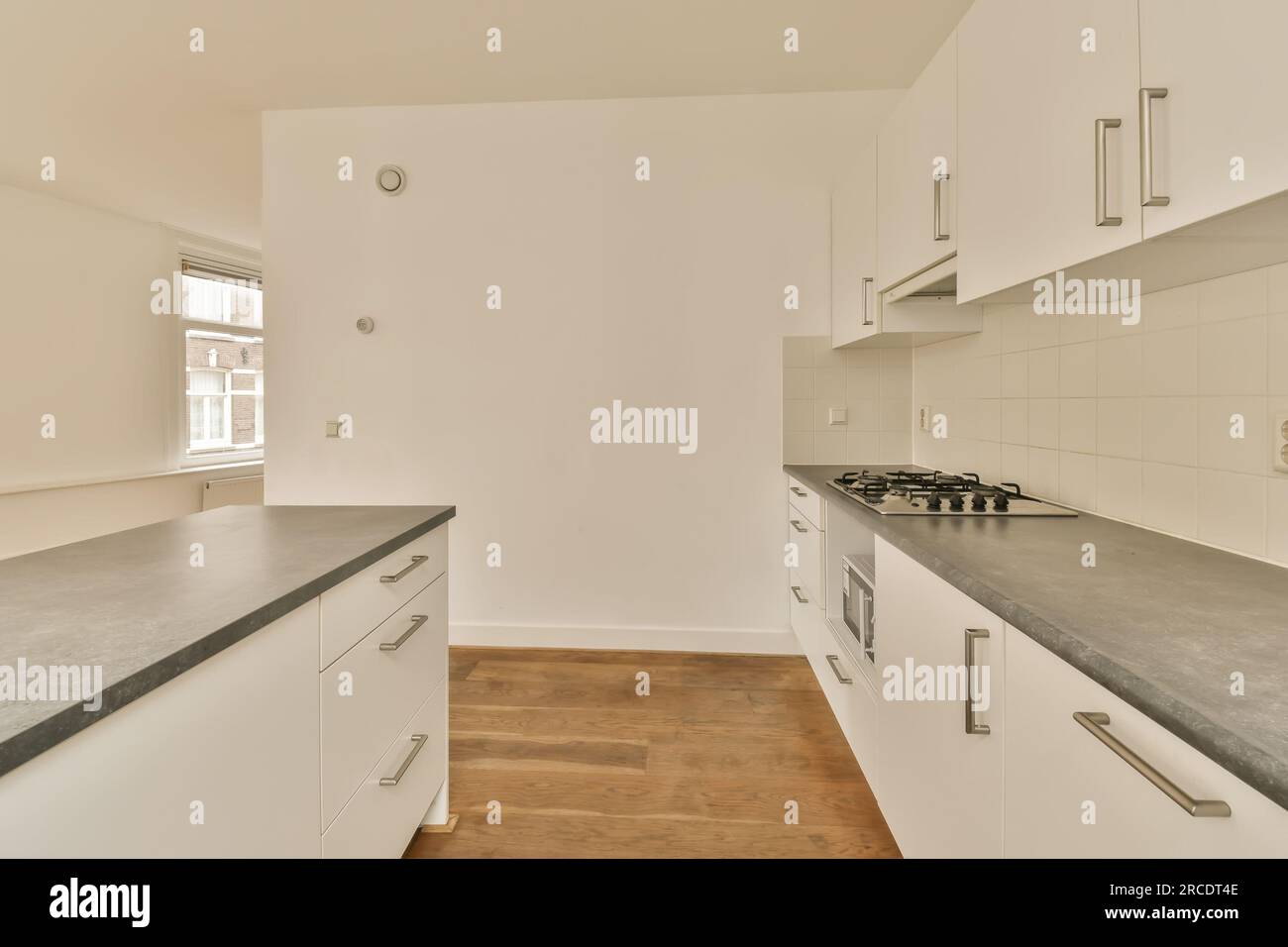 a kitchen with white cupboards and black counter tops on the counters ...