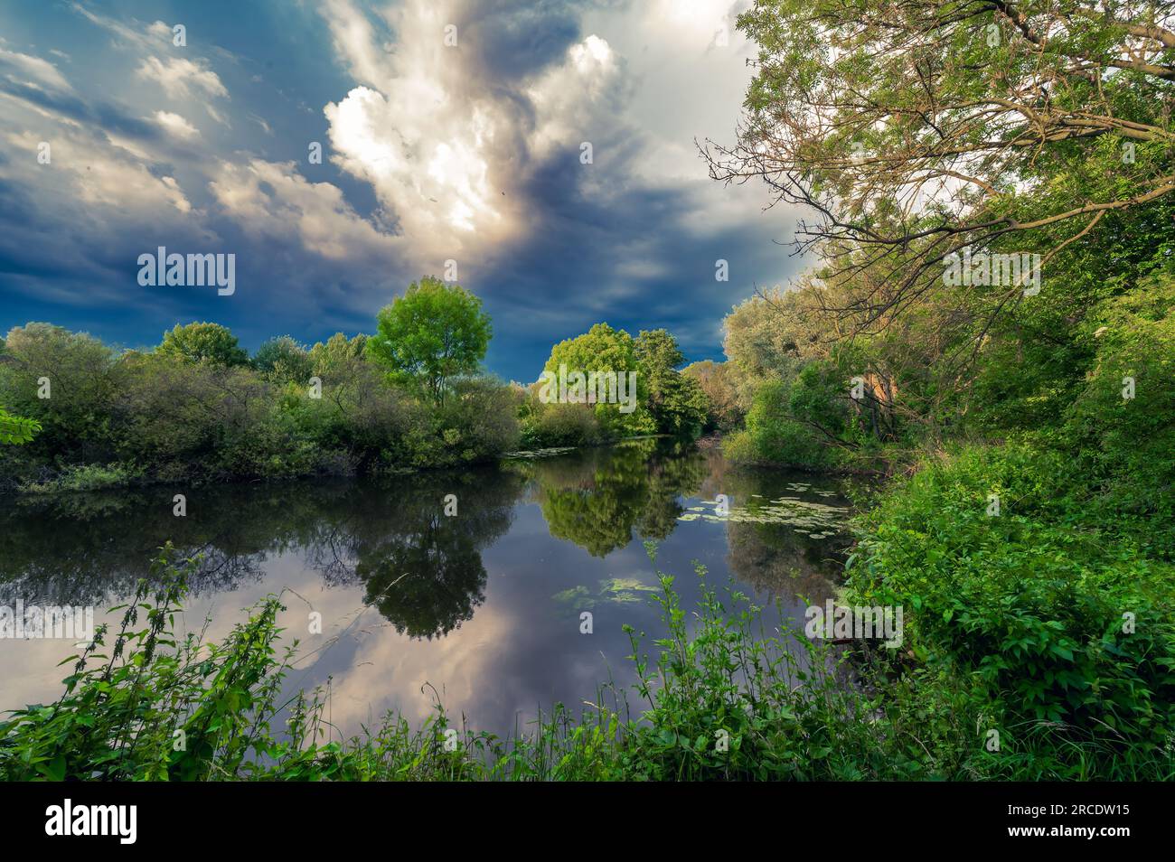dramatic cloud formation is reflected on the water surface of the lake ...